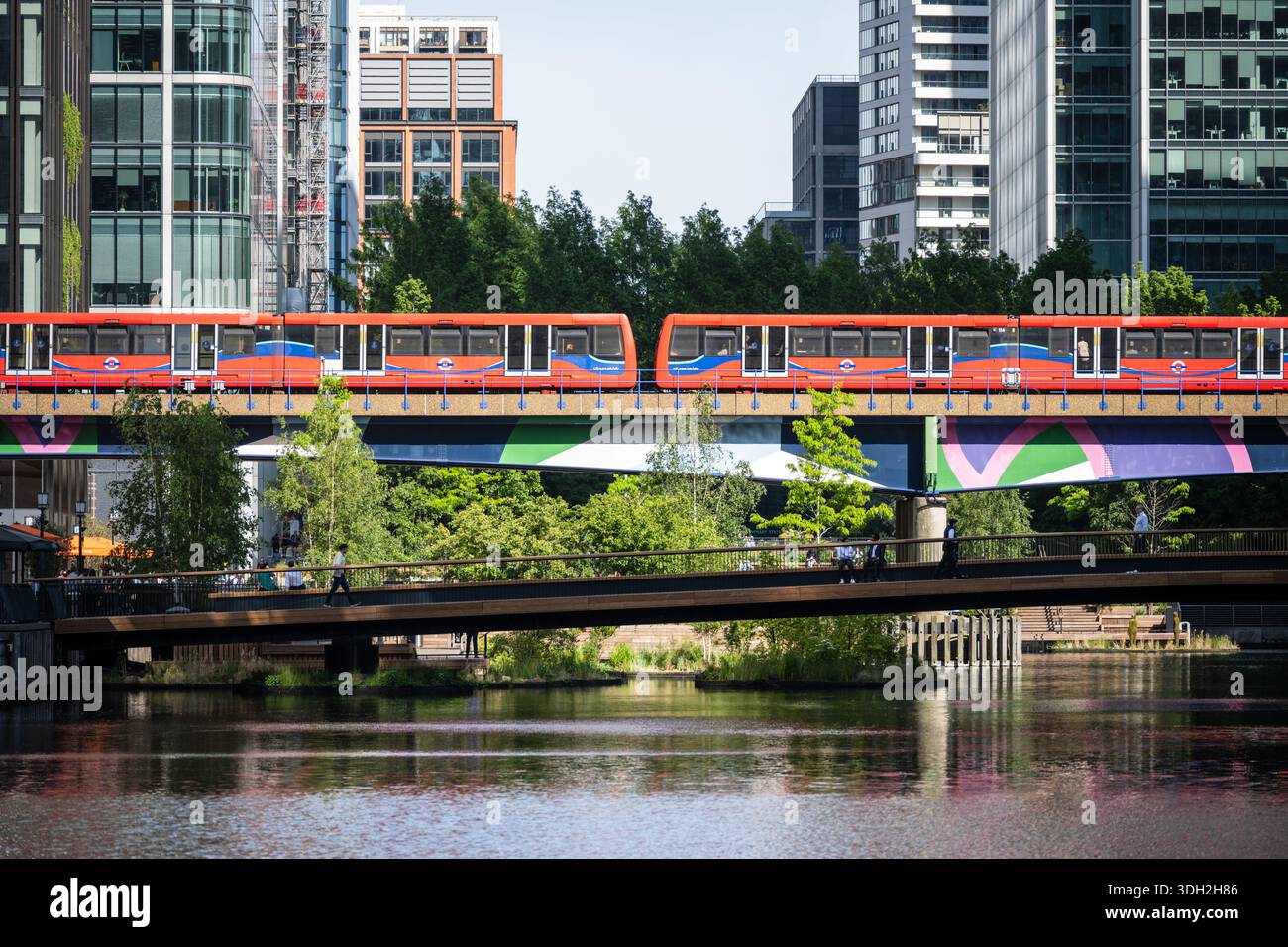 A Docklands Light Railway train crosses the Eden Dock park in London's ...