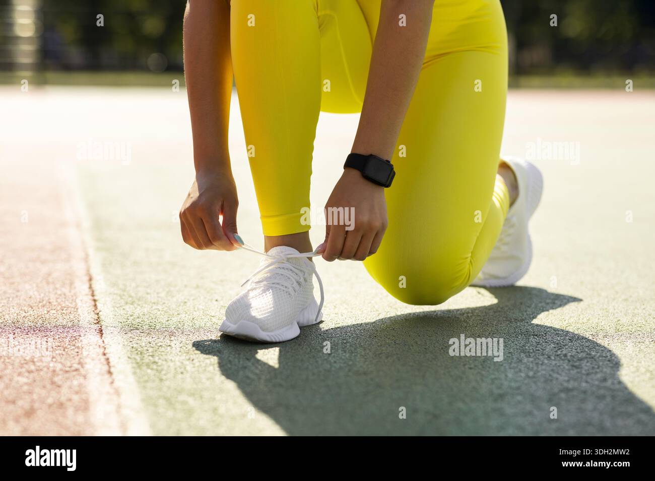 Black Woman In Yellow Sportswear Tying Shoelace On Stadium Stock Photo ...