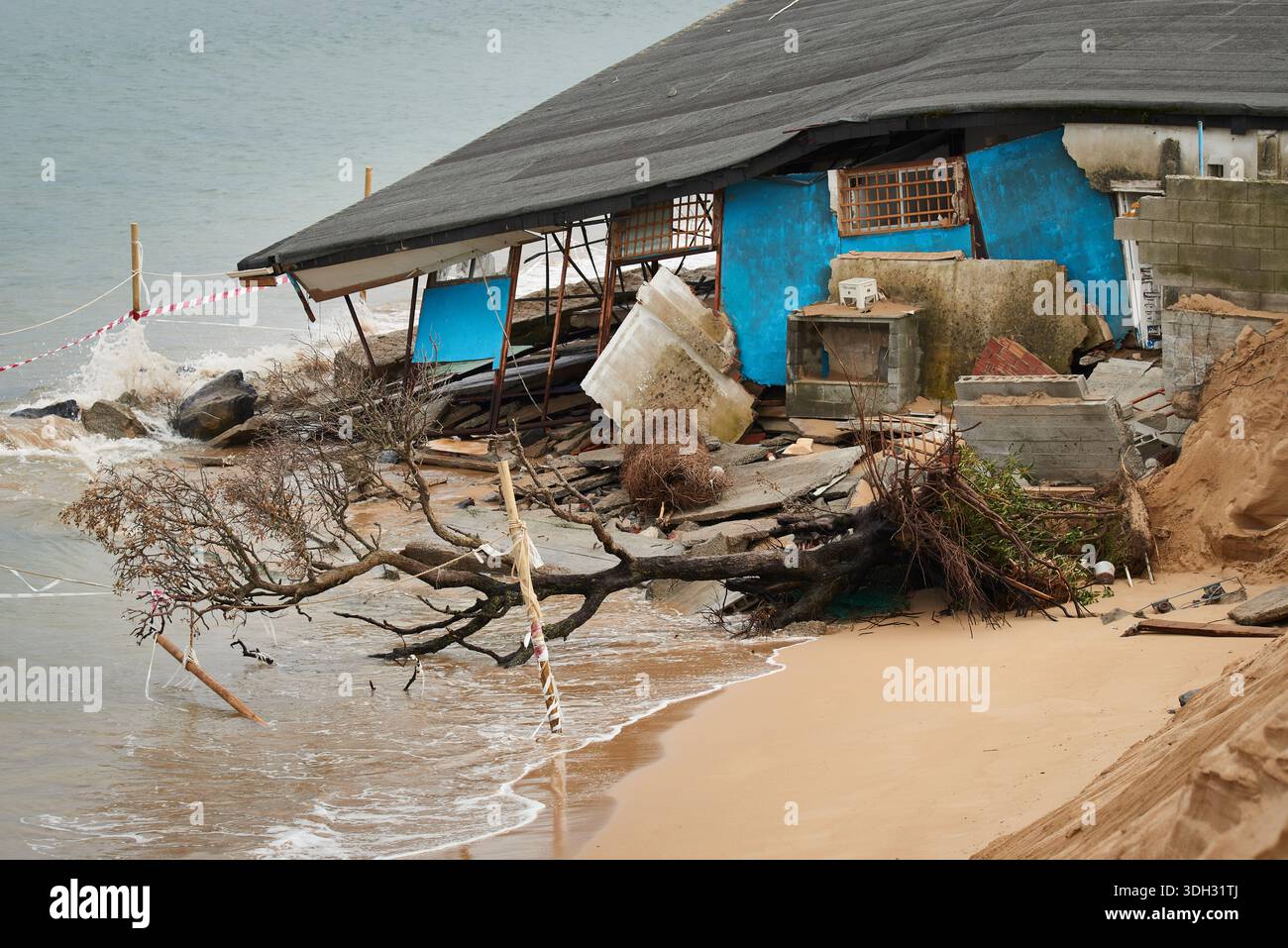 Building collapsing into the sea, showing coastal erosion and ...