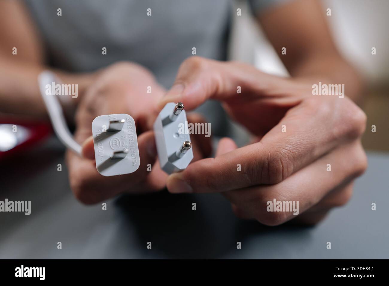 Male hands holding electrical plug with uk type g connector and ...