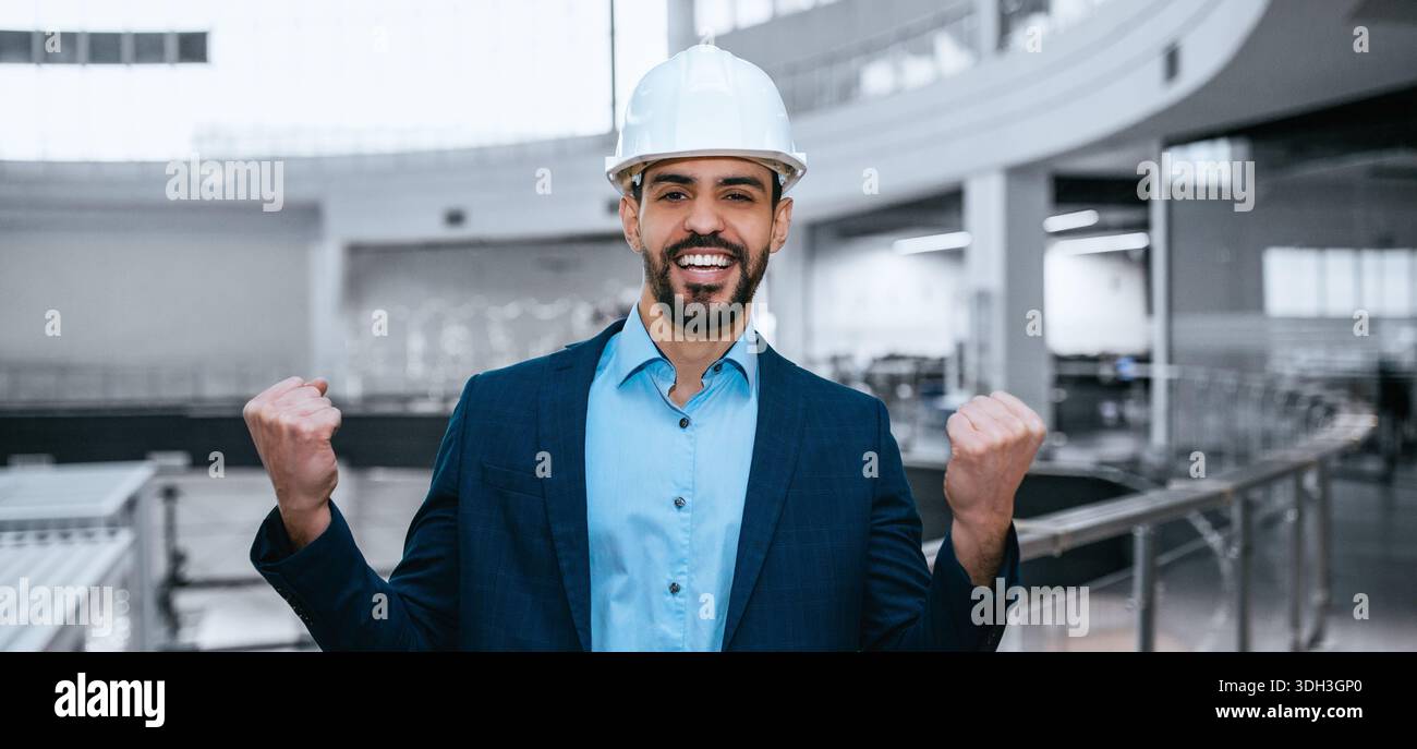 Man Celebrates Success in Industrial Facility Wearing Safety Helmet and ...