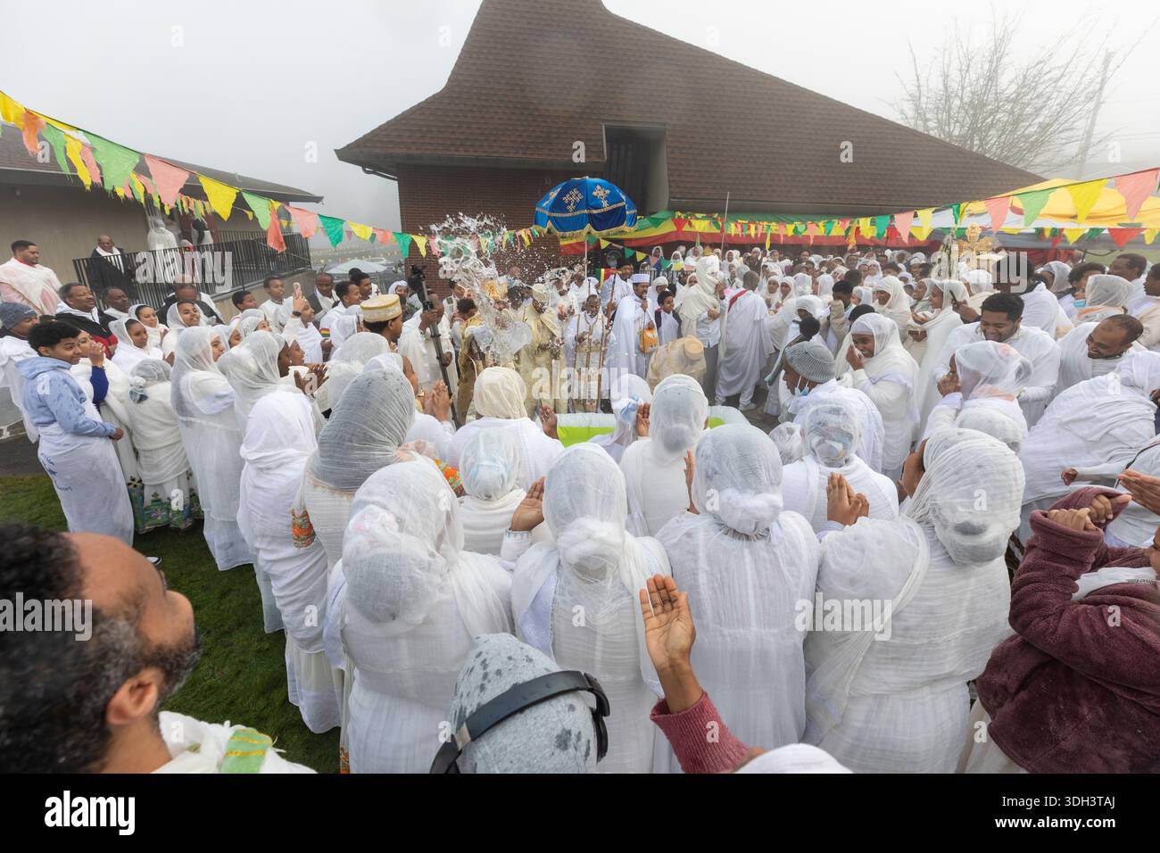 Seattle, Washington, USA. 19 January 2026. Priests splash congregants ...