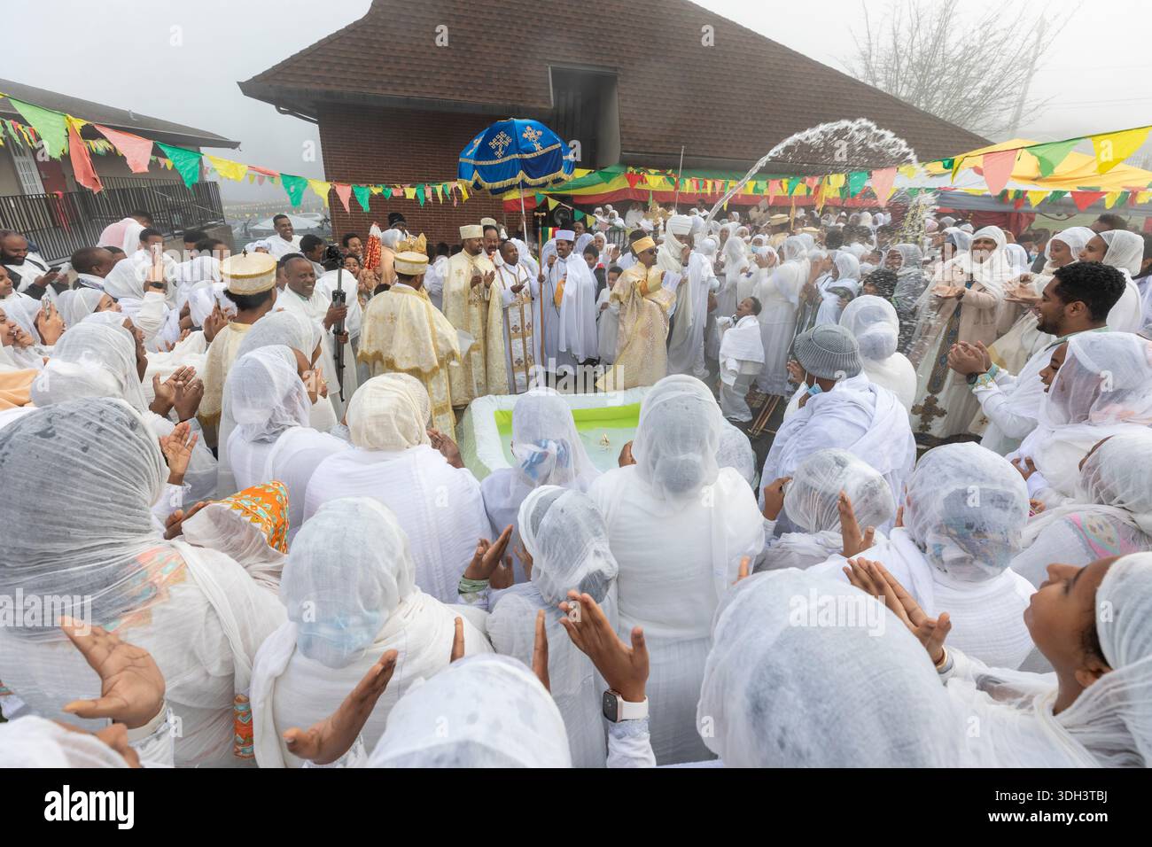 Seattle, Washington, USA. 19 January 2026. Priests splash congregants ...