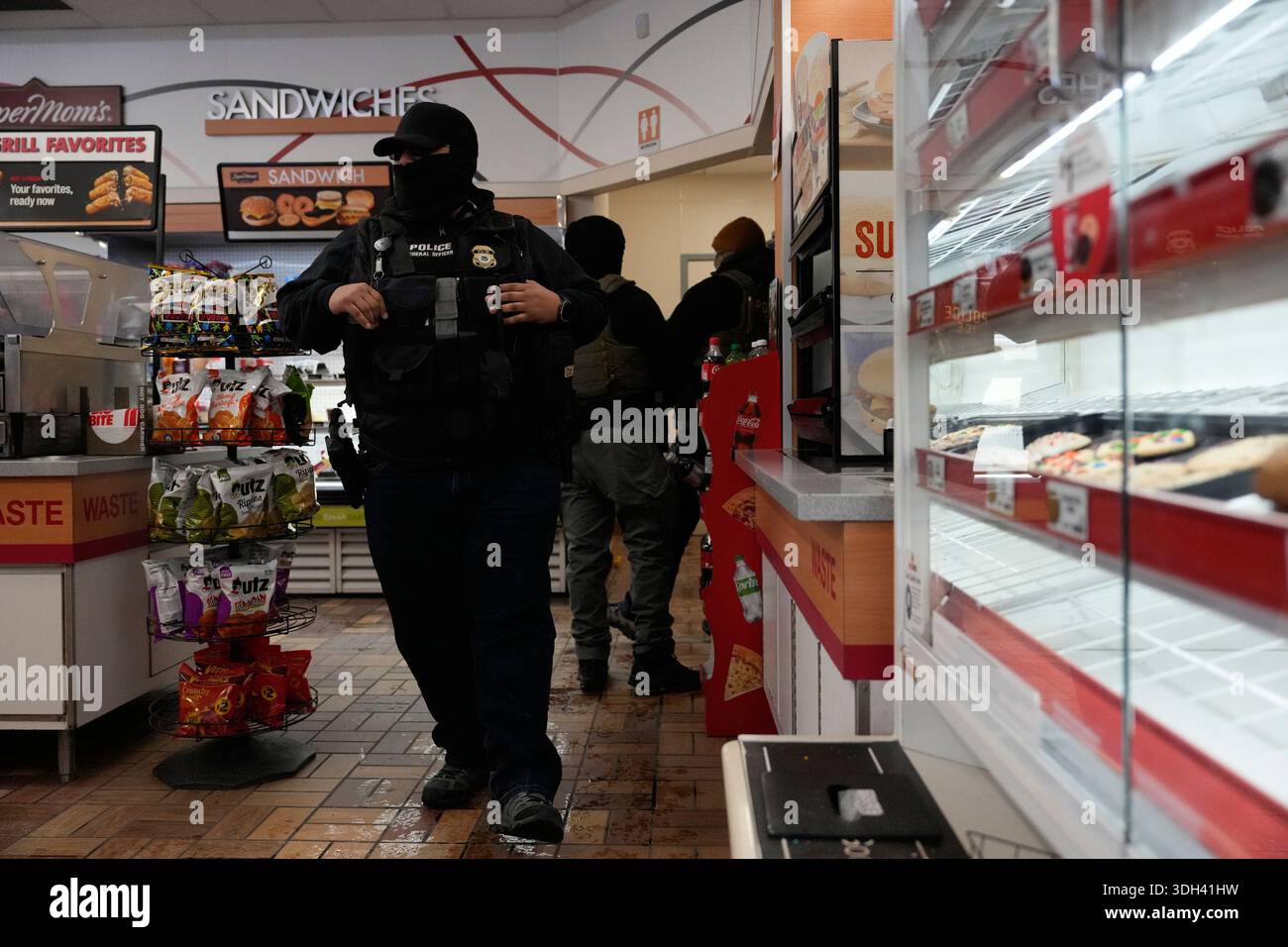 ICE agents make use of the facilities at a gas station, Monday, Jan. 19 ...