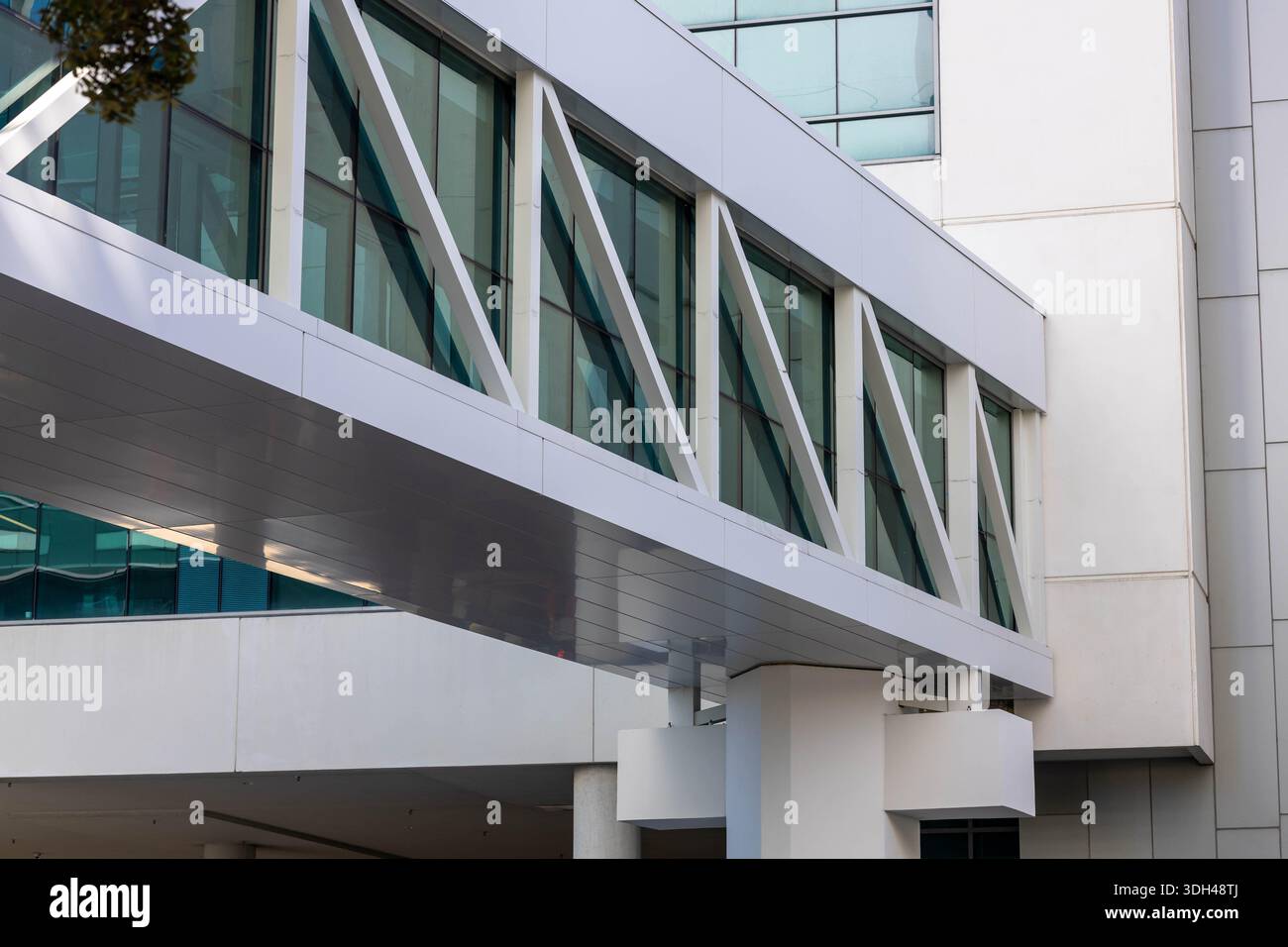 A low angle view of a modern white pedestrian skybridge connecting two ...