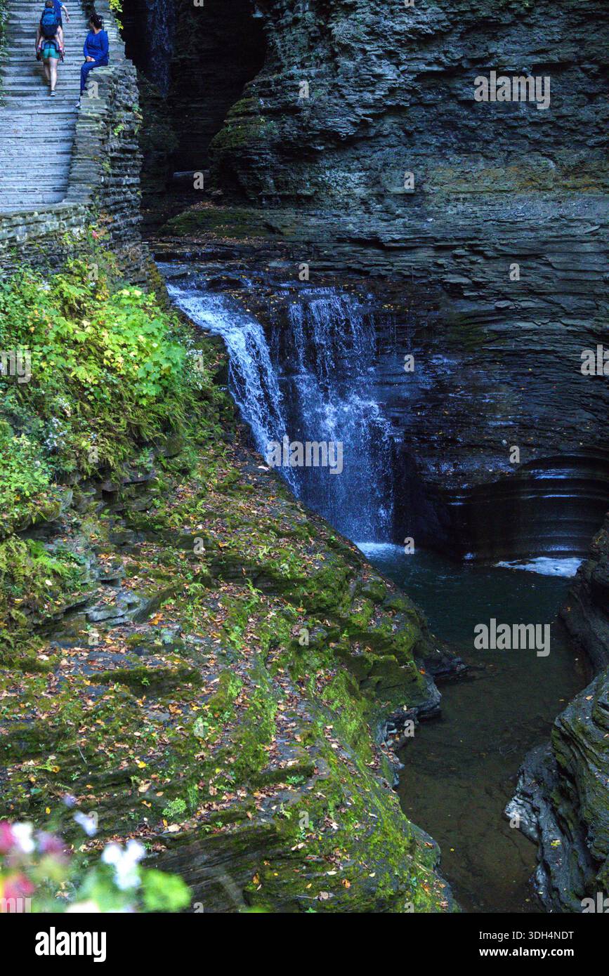 Tall canyon corridor with stone stairs and visitors exploring dramatic ...