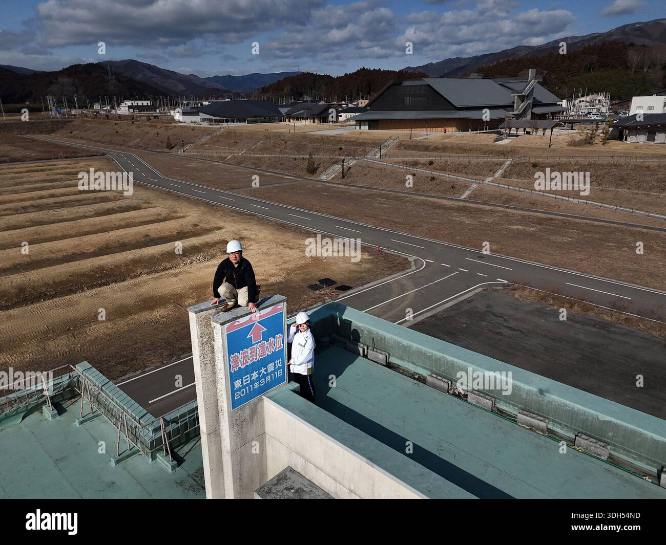 A drone photo shows Yuichi Yonezawa (left) standing atop the chimney of ...