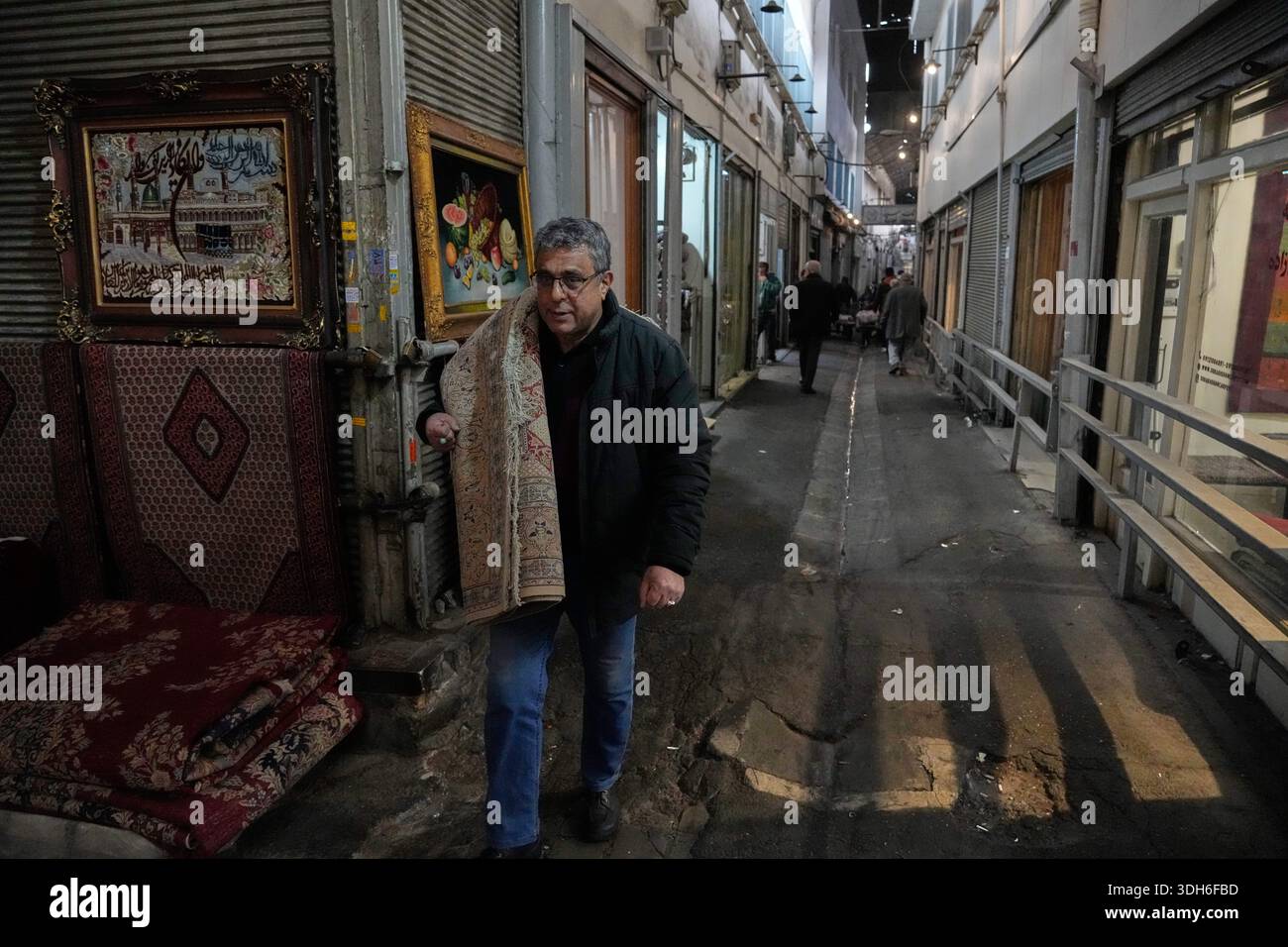 A man carries a carpet at Tehran's historic Grand Bazaar, Tuesday, Jan ...