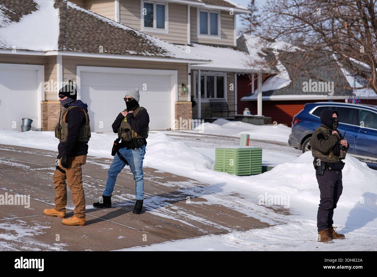 Federal immigration officers stand outside of a home Tuesday, Jan. 20 ...