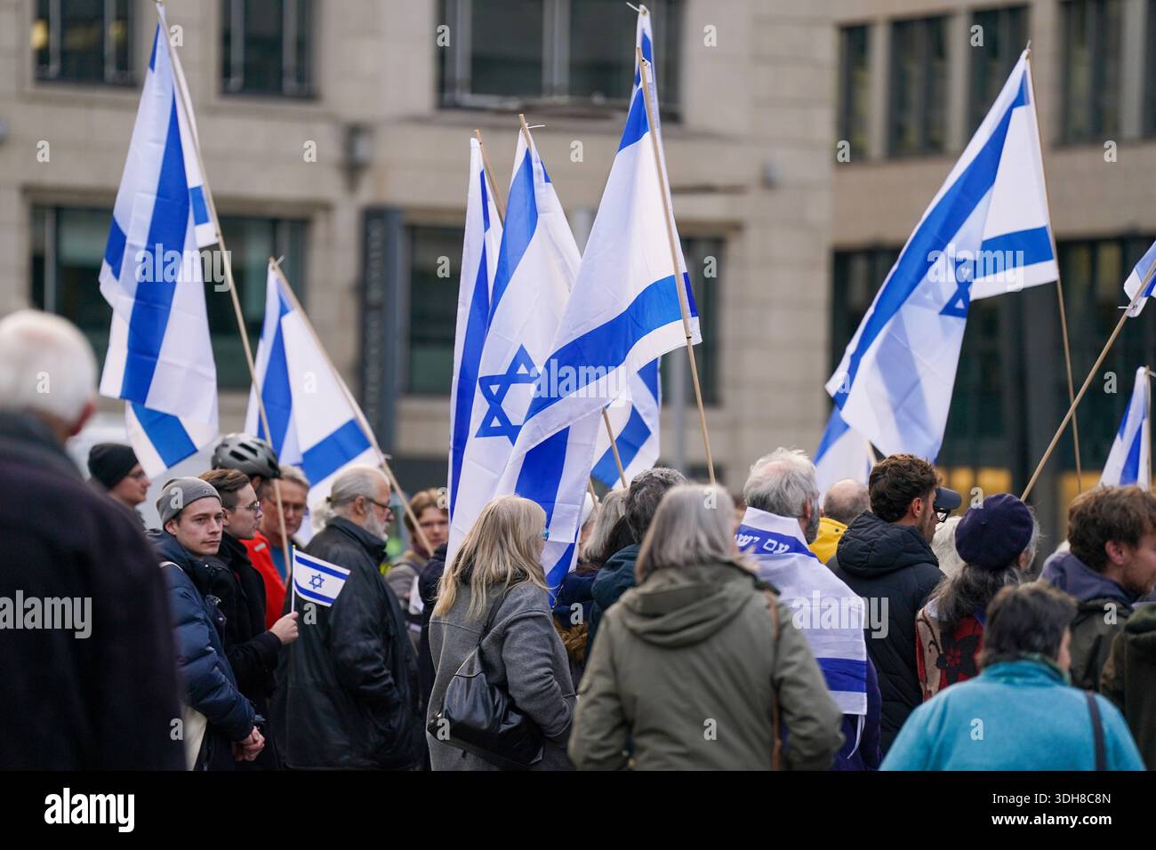 Teilnehmende einer Solidaritätskundgebung versammeln sich mit ...