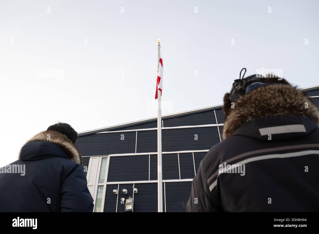 Onlookers watch as the flag of Greenland is raised outside the Nunavut ...