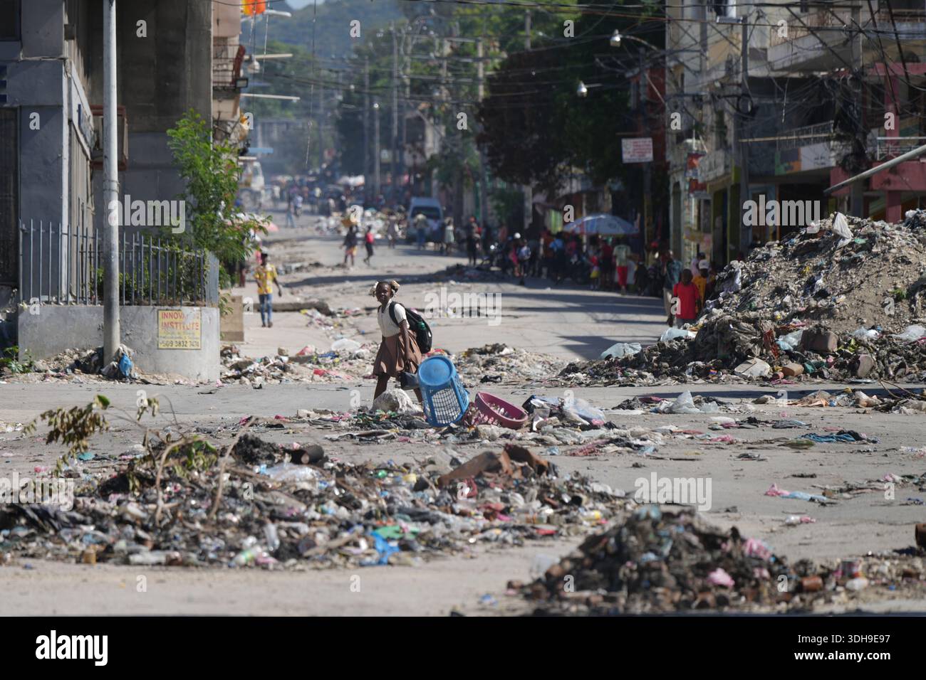 A youth crosses a street littered with garbage in downtown in Port-au ...