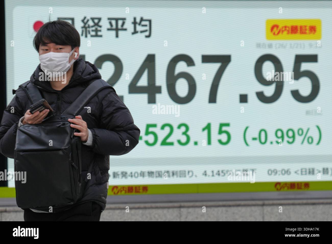 A person walks in front of an electronic stock board showing Japan's ...