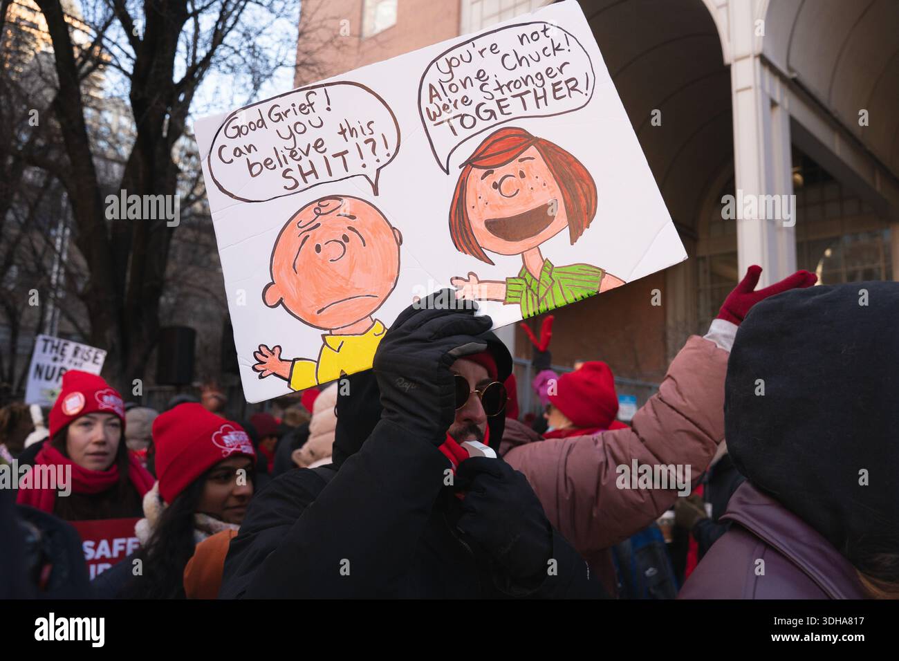 A nurse holds a sign depicting Charlie Brown and Peppermint Patty ...
