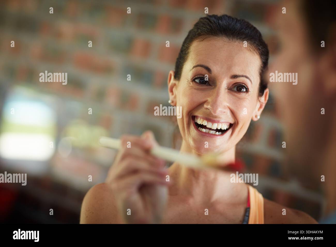 Happy couple, woman and feed in kitchen with spoon, healthy meal and ...