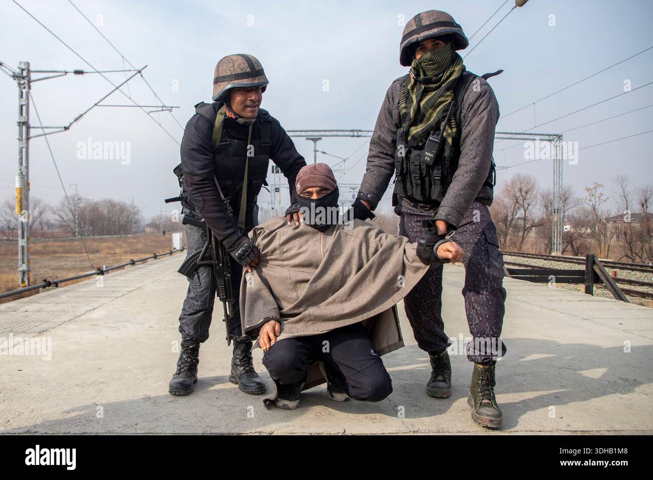Indian security personnel detain a colleague dressed as a militant ...