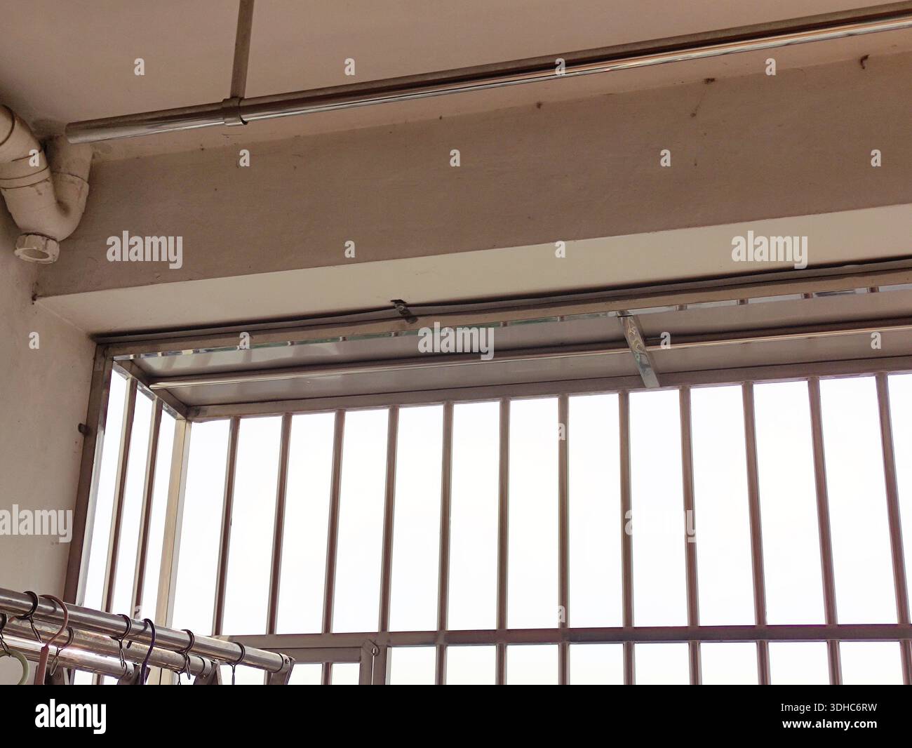 Metal security bars installed on a window with visible pipes and ...