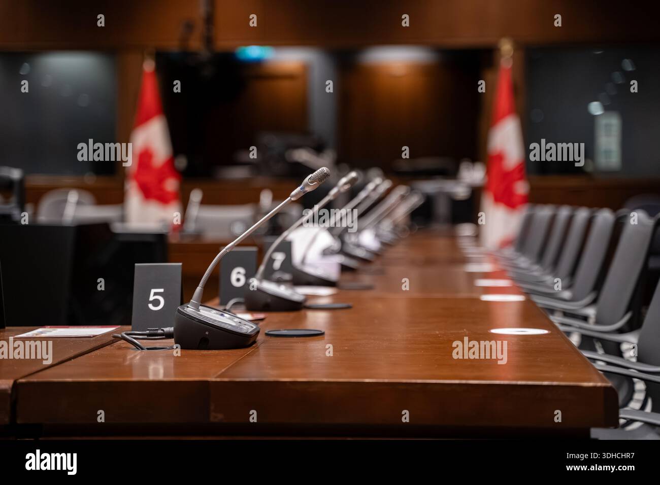 Close up of conference microphones on meeting table with empty chairs ...