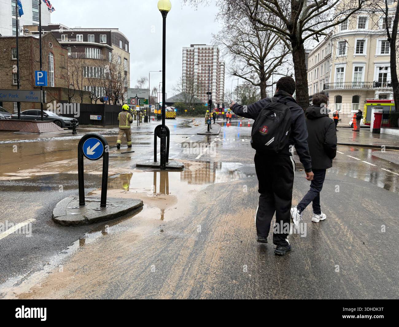 London, UK. 21 January 2026. Pedestrians walk across a muddy, water ...