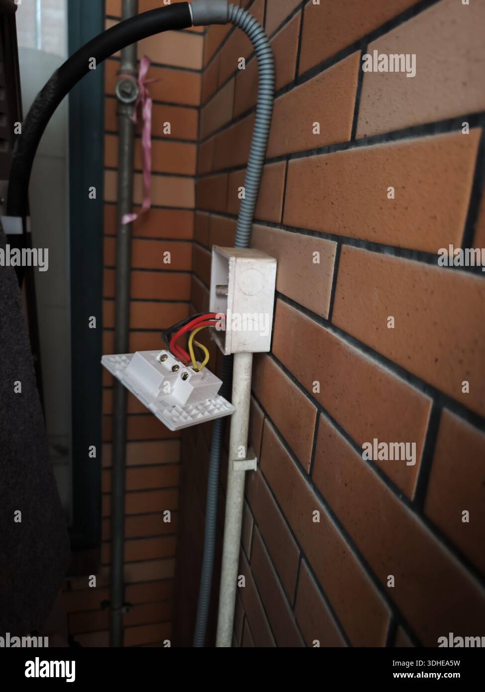 Electrical outlet with exposed wiring mounted on brick wall Stock Photo ...