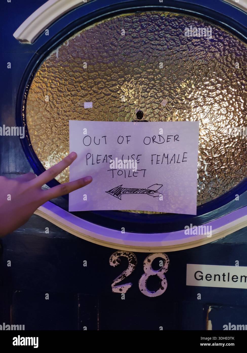 Hand pointing to "Out of Order" sign directing to female toilet ...