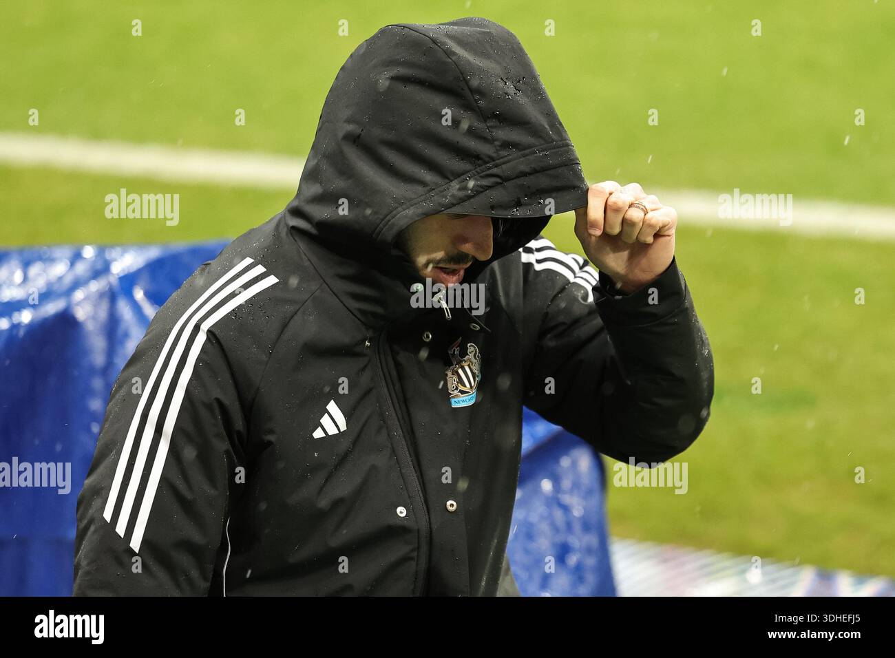 Sandro Tonali of Newcastle Untied pulls his hood over his face as rain ...