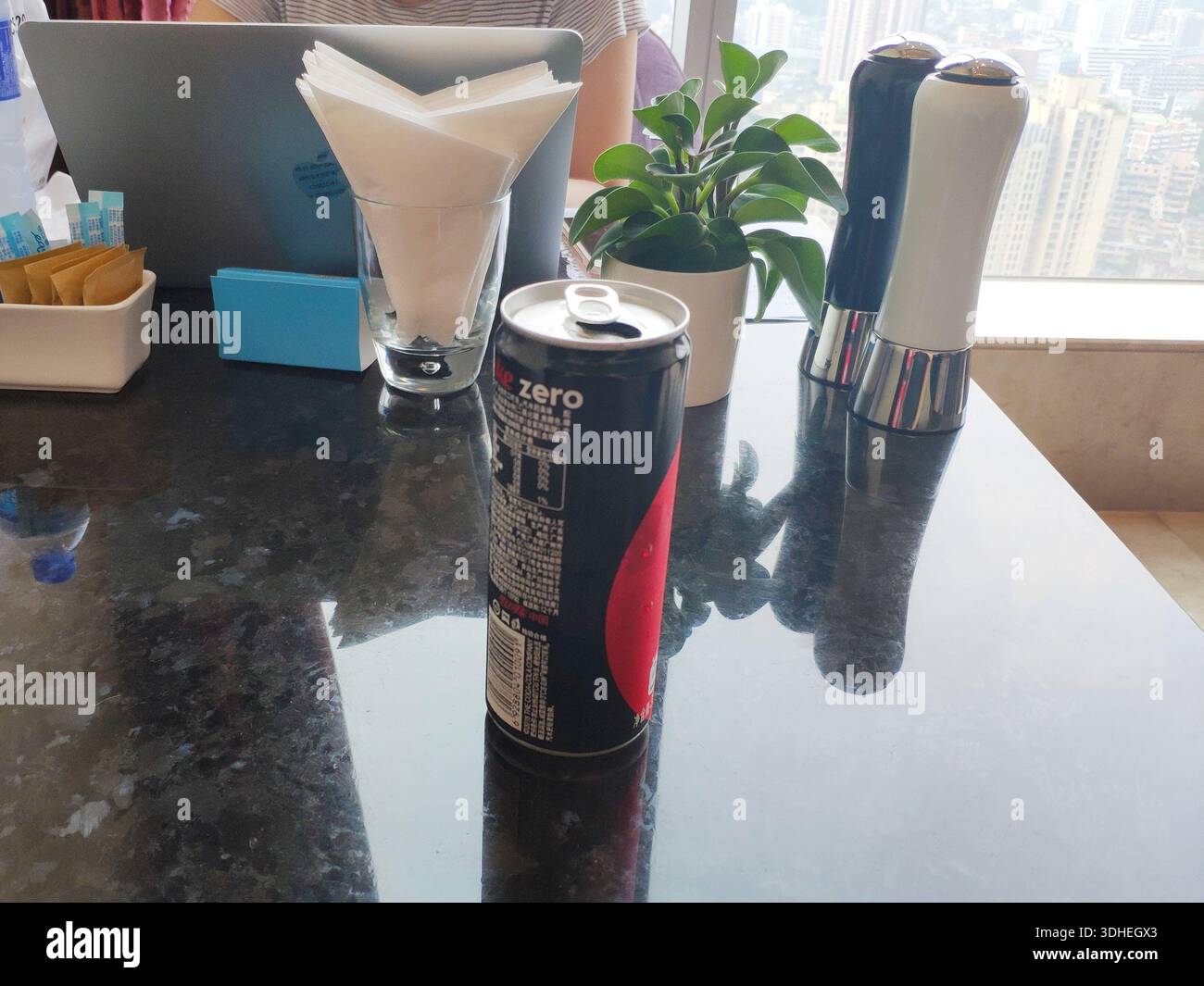 A can of zero-sugar soda on a reflective kitchen countertop with urban ...