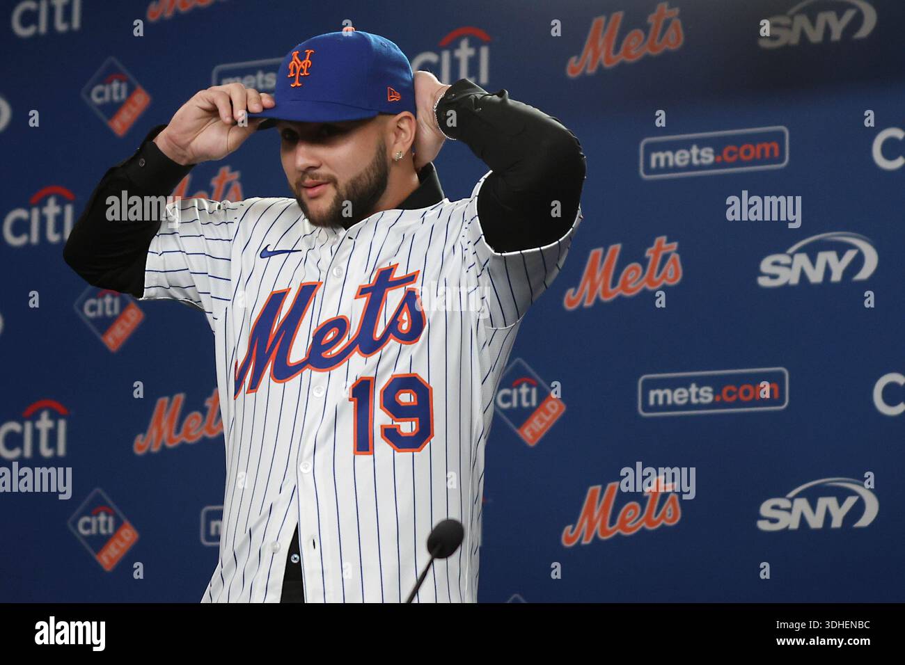 Bo Bichette puts on his hat and jersey during his introductory press ...