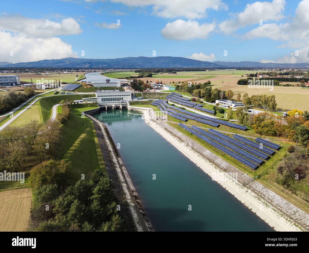 Aerial view of a hydro power plant with solar panels, highlighting ...
