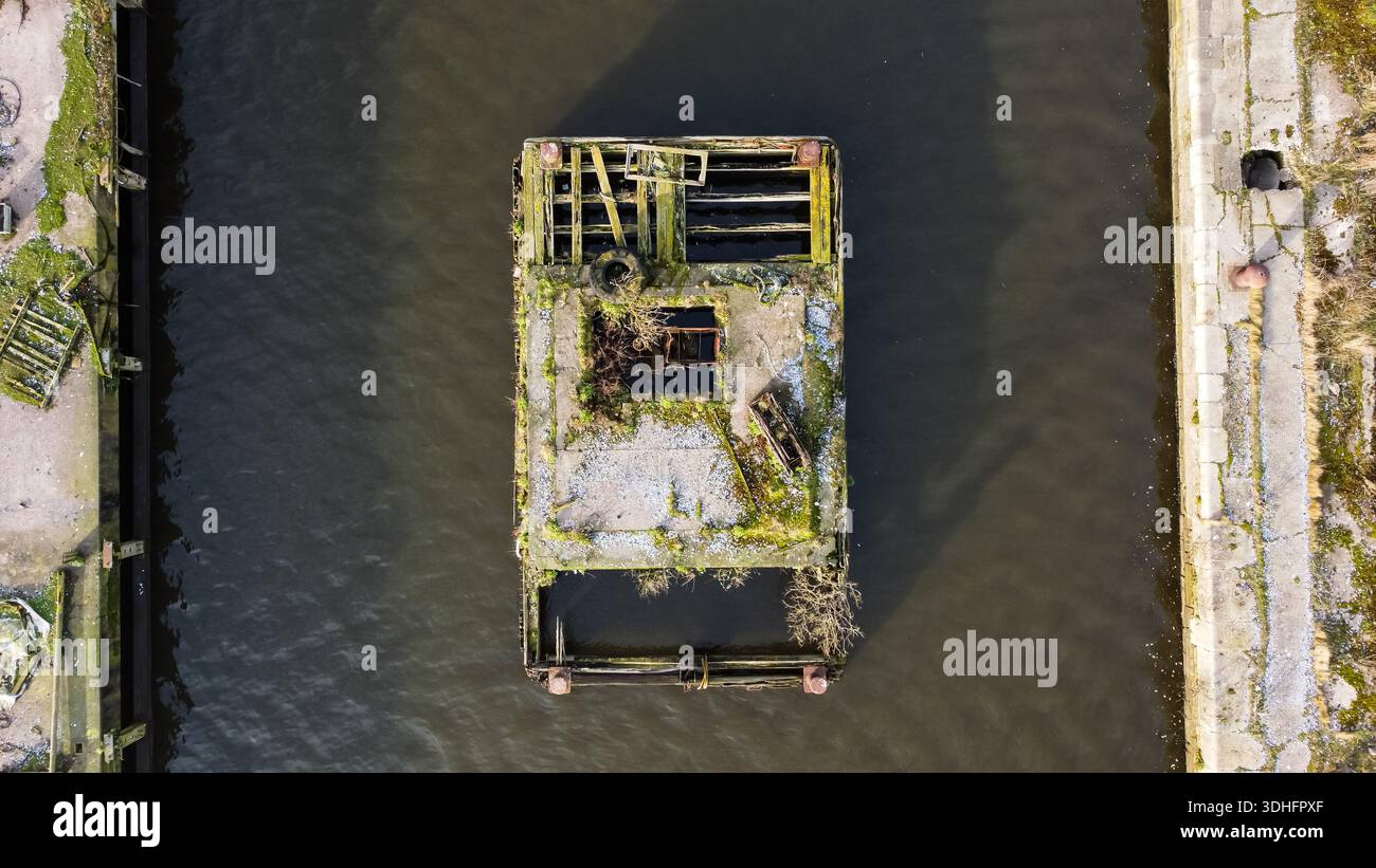 Aerial view of derelict dock structure surrounded by water at East ...