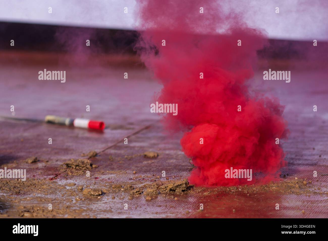 Details with a red smoke flare thrown on the ground, in mud Stock Photo ...
