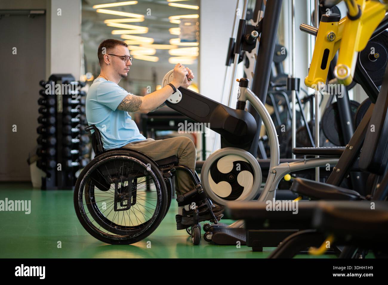 Disabled man in wheelchair working on increasing upper body strength ...