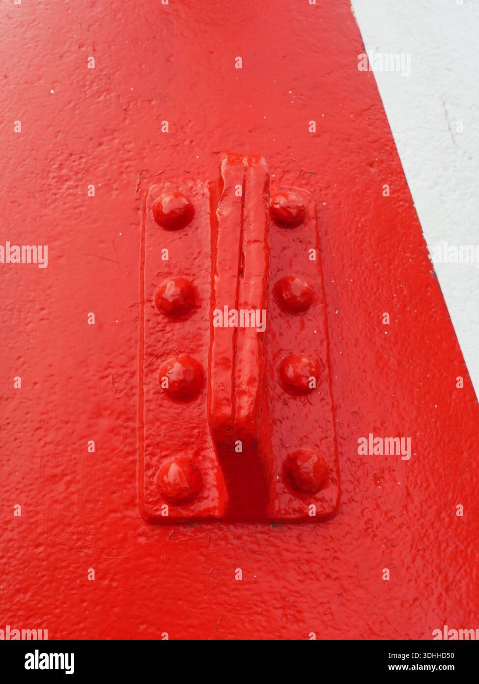 Lifting eye on red, painted steel surface, part of a larger technical ...