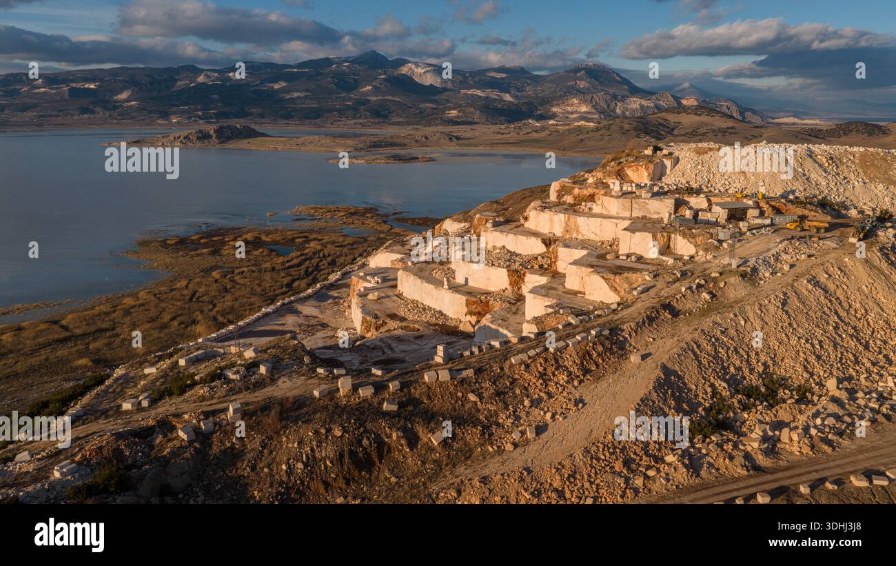 A panoramic aerial view of the marble quarry site by the lake. An ...