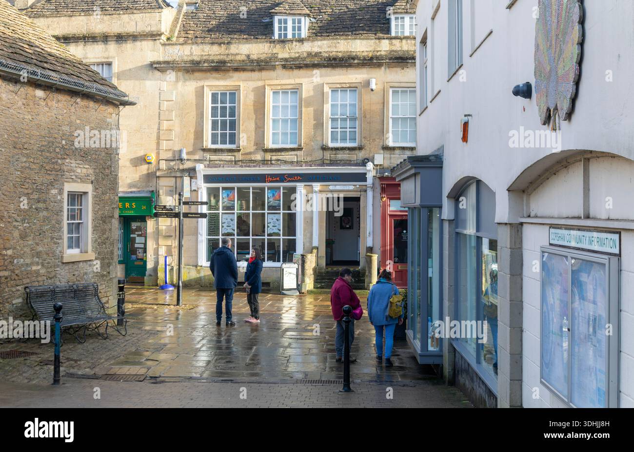 People in street wet surfaces after rain in town centre of Corsham ...