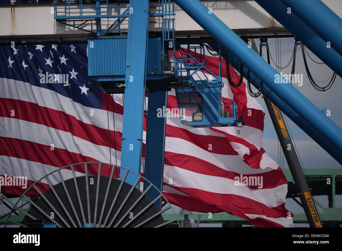 A crane operator loads a container onto a ship at the Gloucester Marine ...