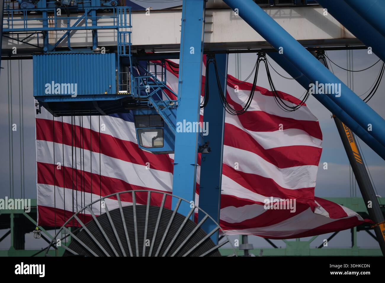 A crane operator loads a container onto a ship at the Gloucester Marine ...