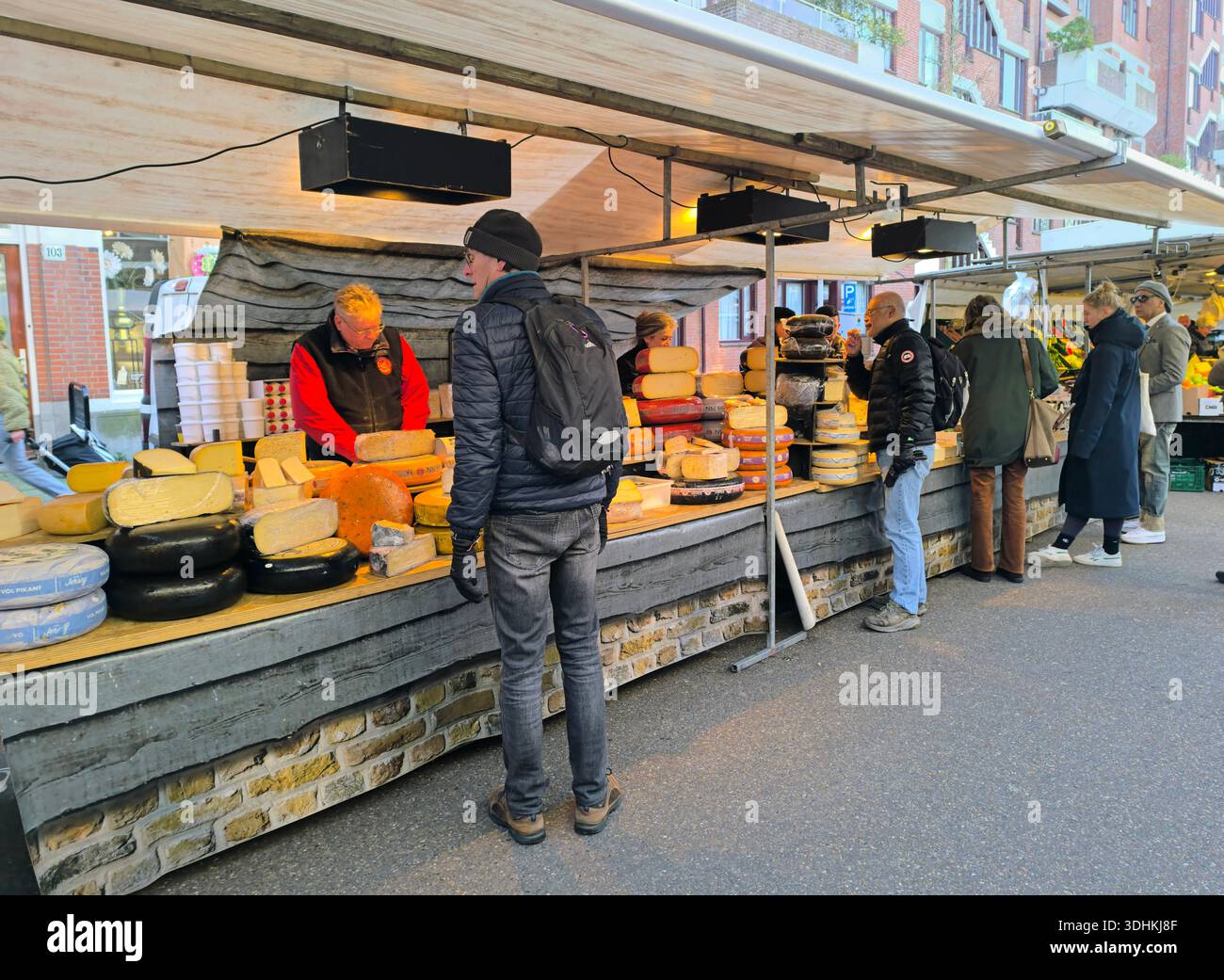 People at a cheese stall on the market during a winter day in ...