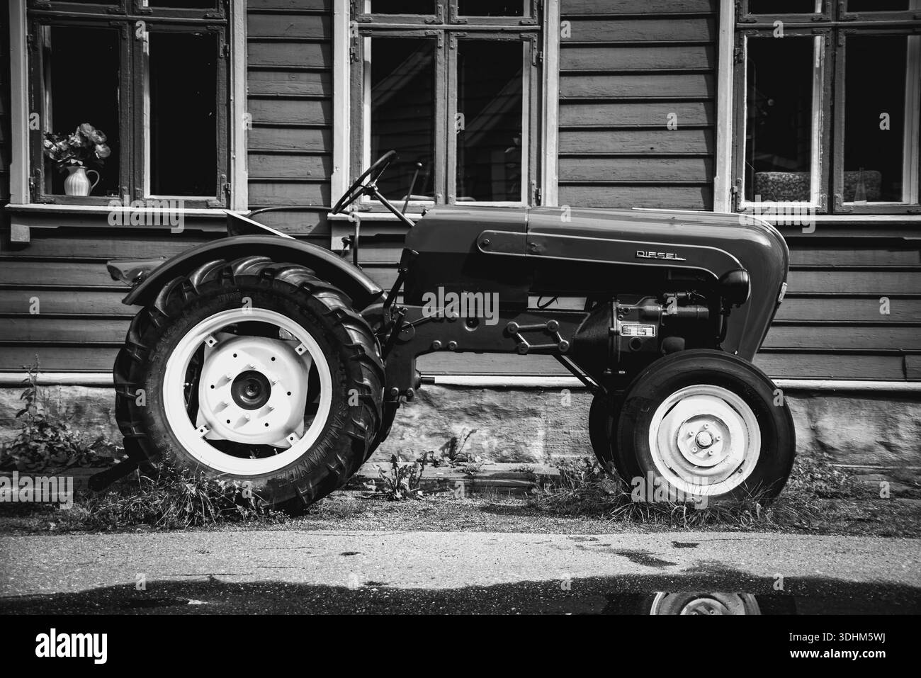 An old good shaped tractor in front of a farm house in Norway Stock ...