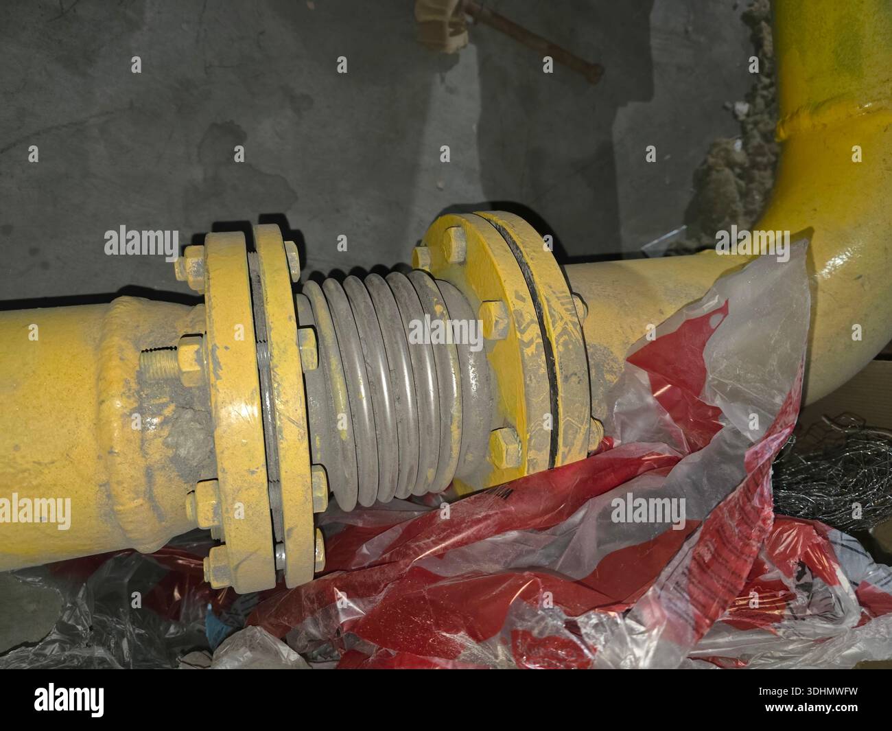 A gas pipe expansion joint is shown with metal flanges and a flexible ...