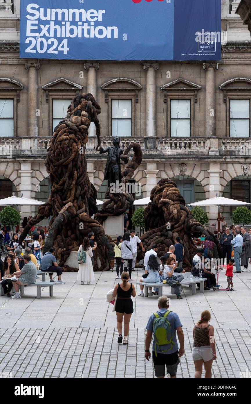 A large sculpture composed of intertwined rope-like forms surrounds a ...