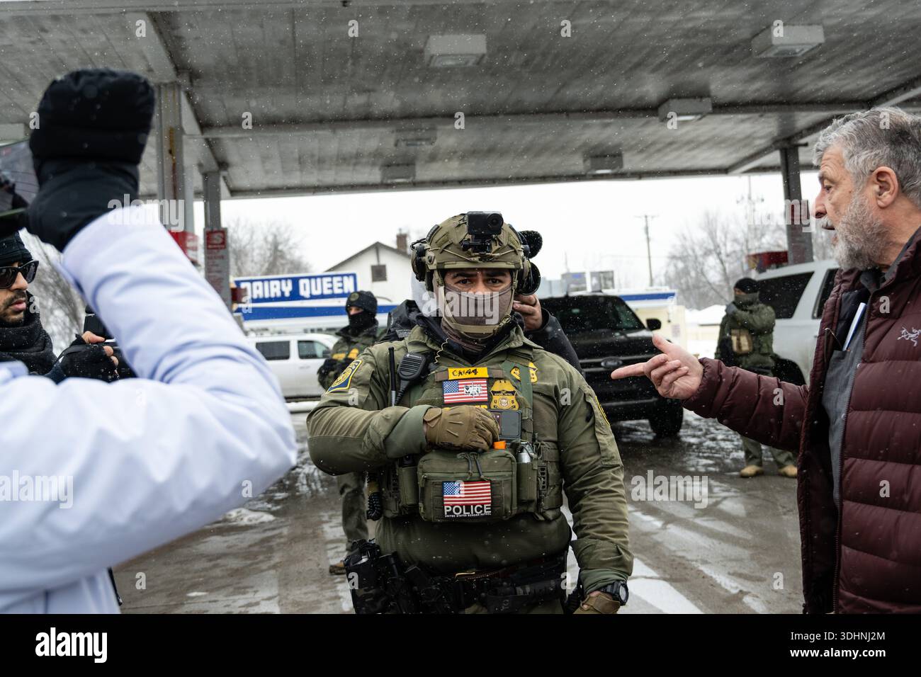 A federal immigration officer faces members of the public during a ...