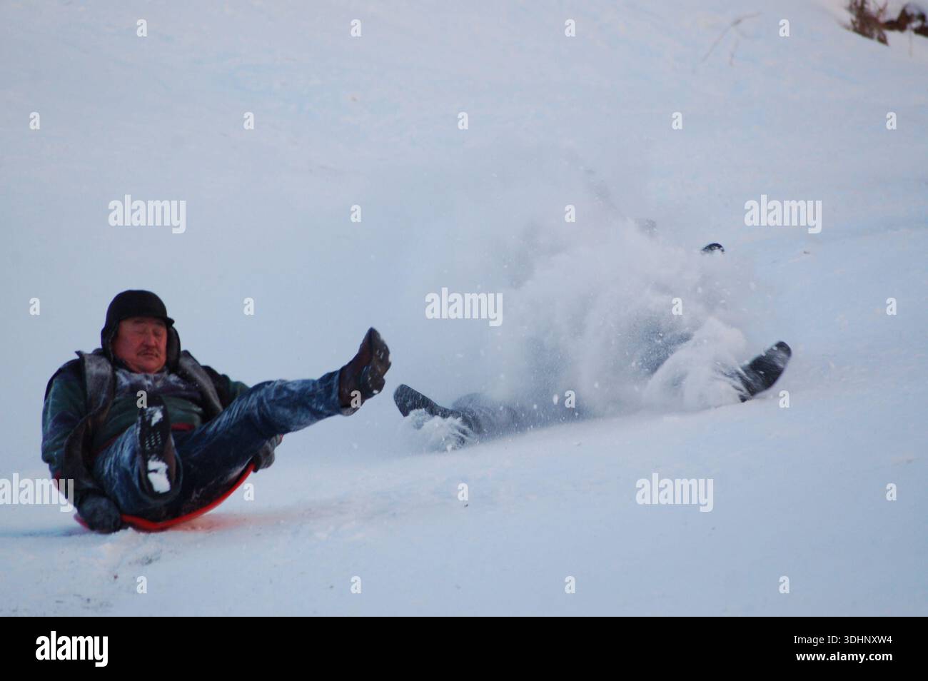 An elderly man sledding down a hill in winter Stock Photo - Alamy