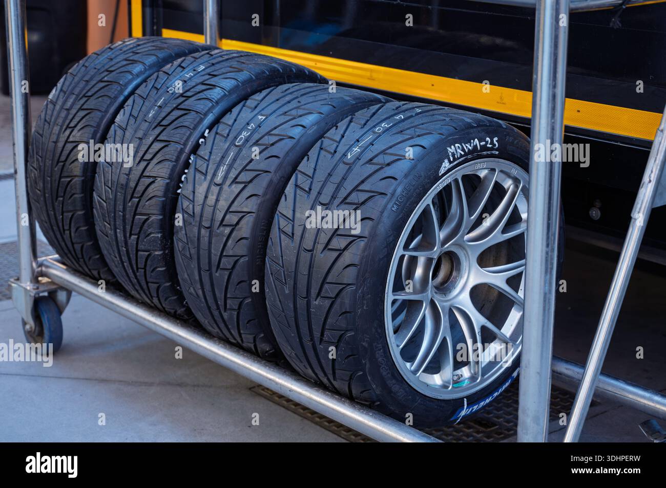 Detail of grooved wet-weather racing tires on a team's pit lane rack ...