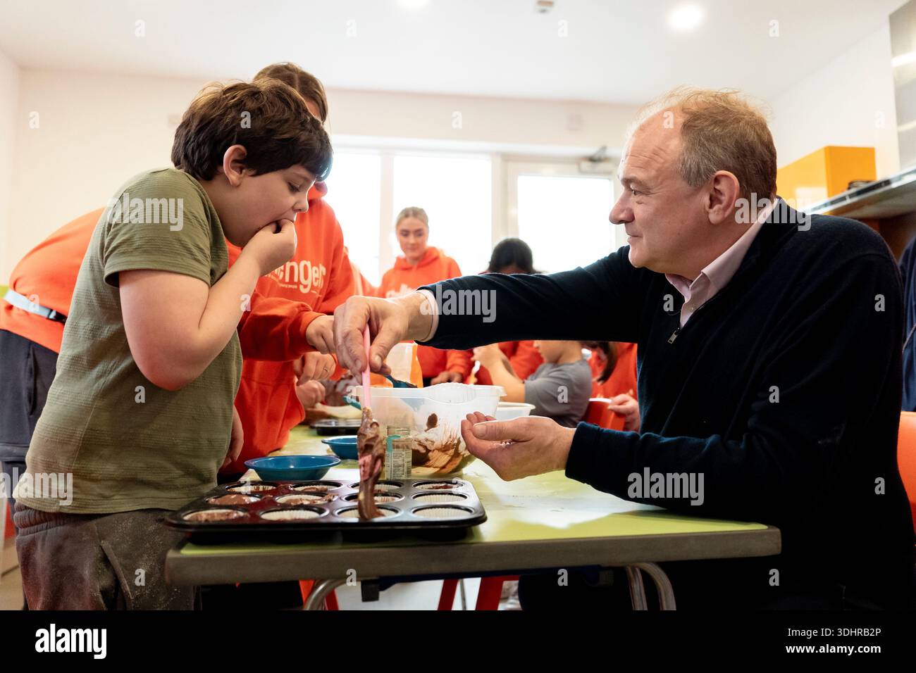Liberal Democrat leader Sir Ed Davey helps a child make cupcakes during ...