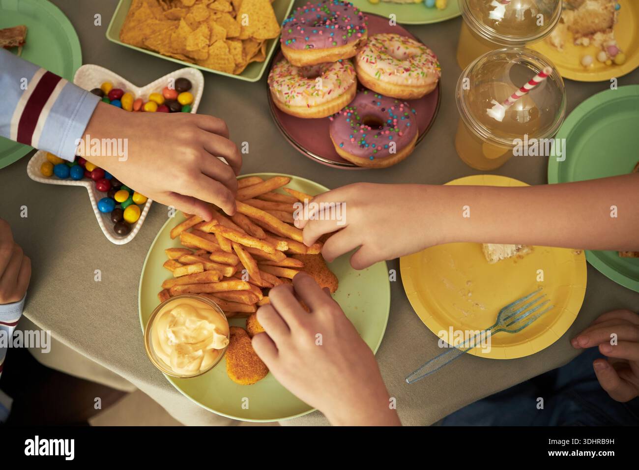 Group of children reaching for French fries and chicken nuggets on ...