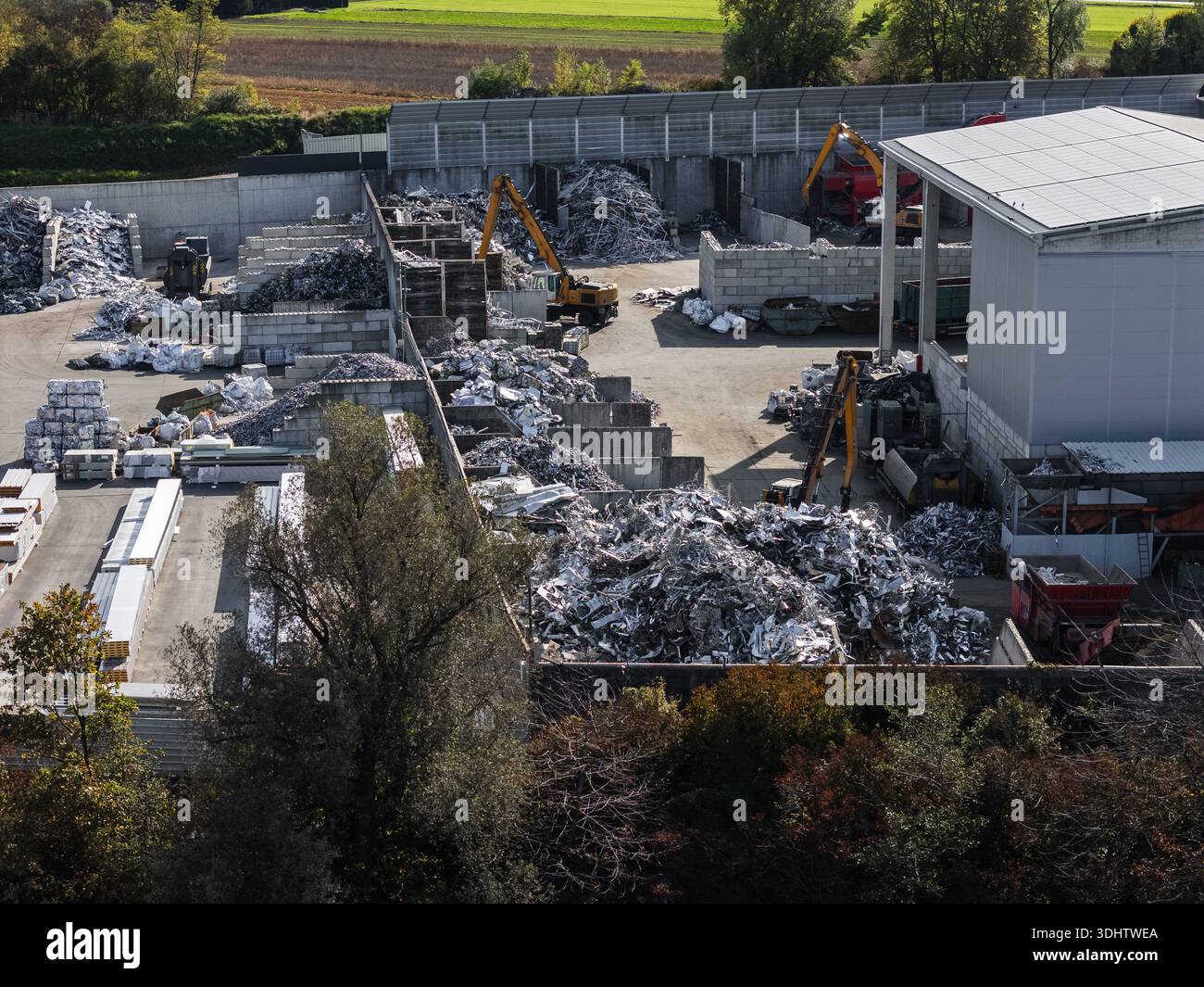 Facility features large scrap metal piles, heavy machinery, and ...