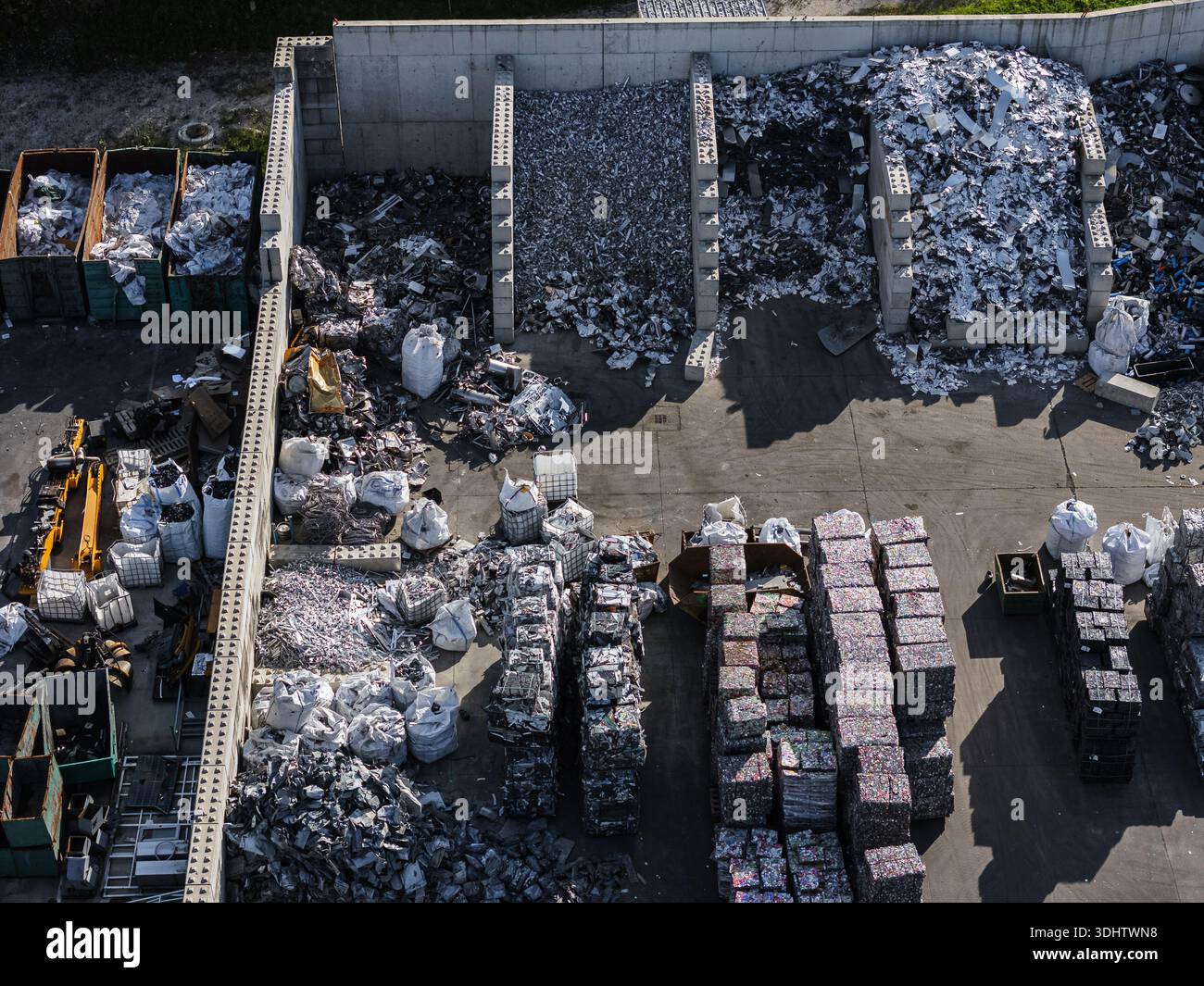 Large piles of scrap metal and processed materials are seen in an ...