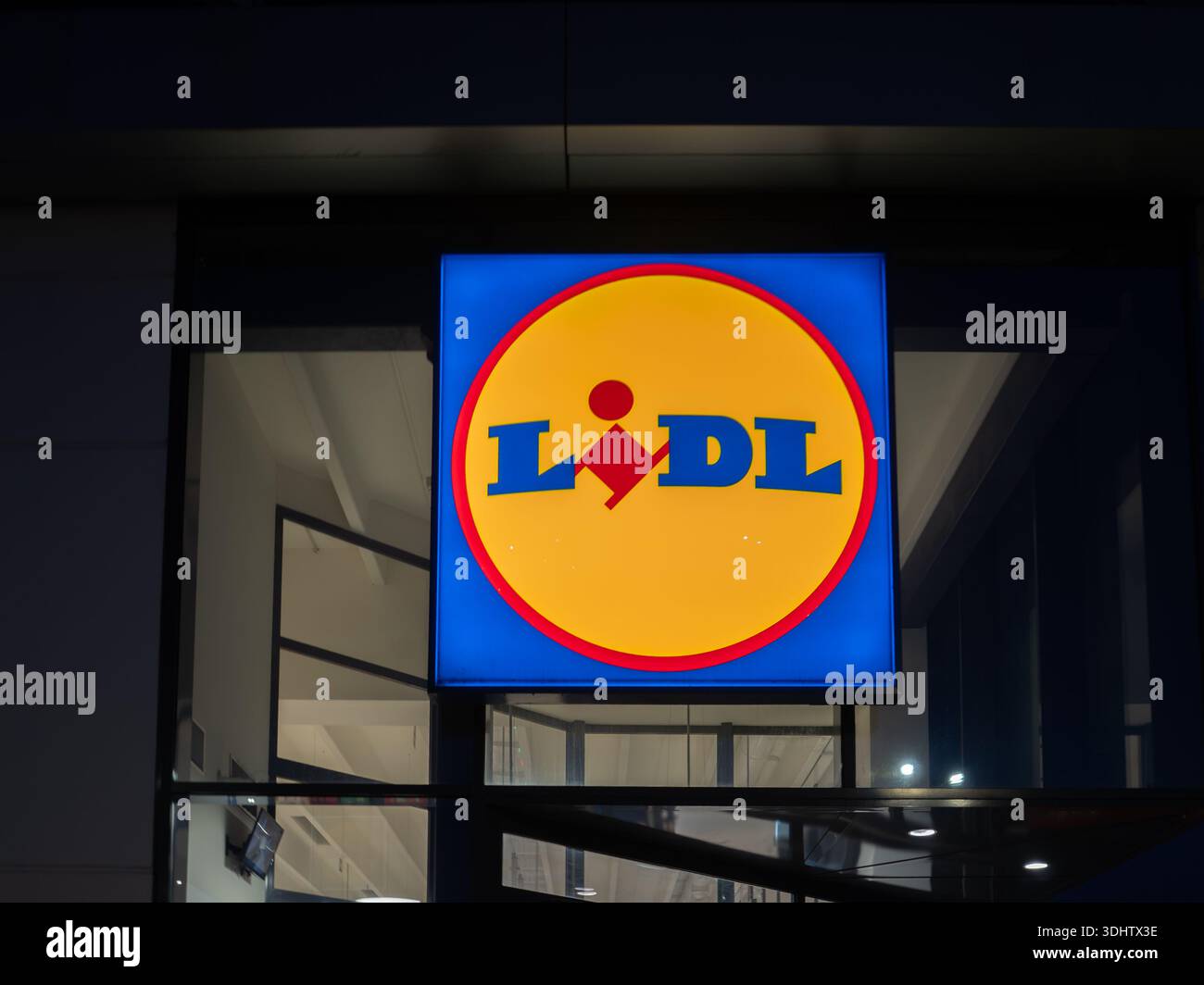 Cremona, Italy January 8th 2026 Lidl store sign glowing on an urban ...