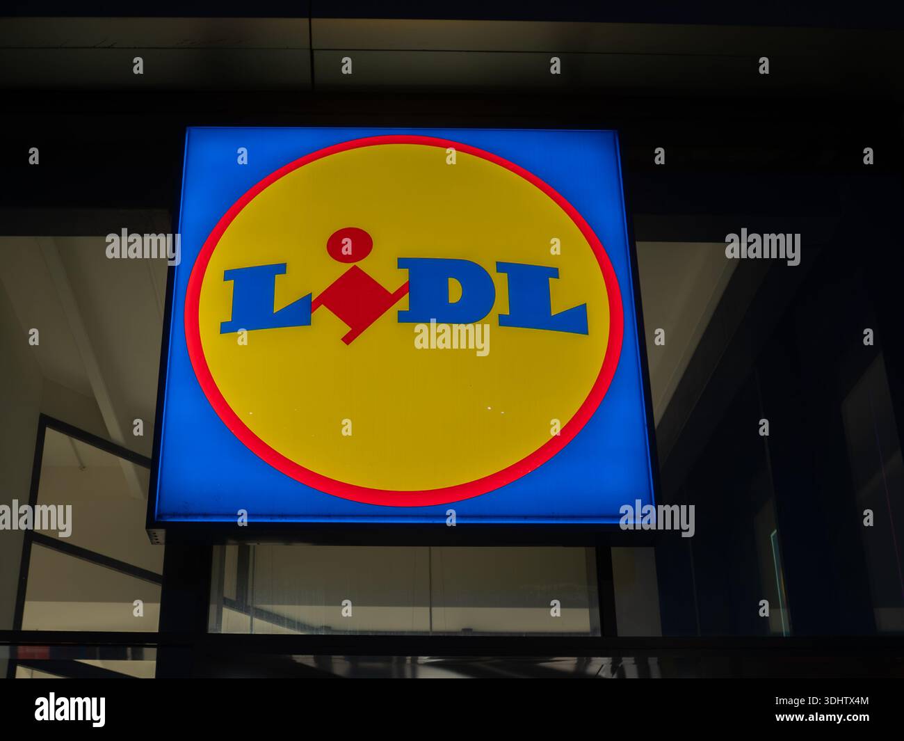 Cremona, Italy January 8th 2026 Lidl store sign glowing on an urban ...